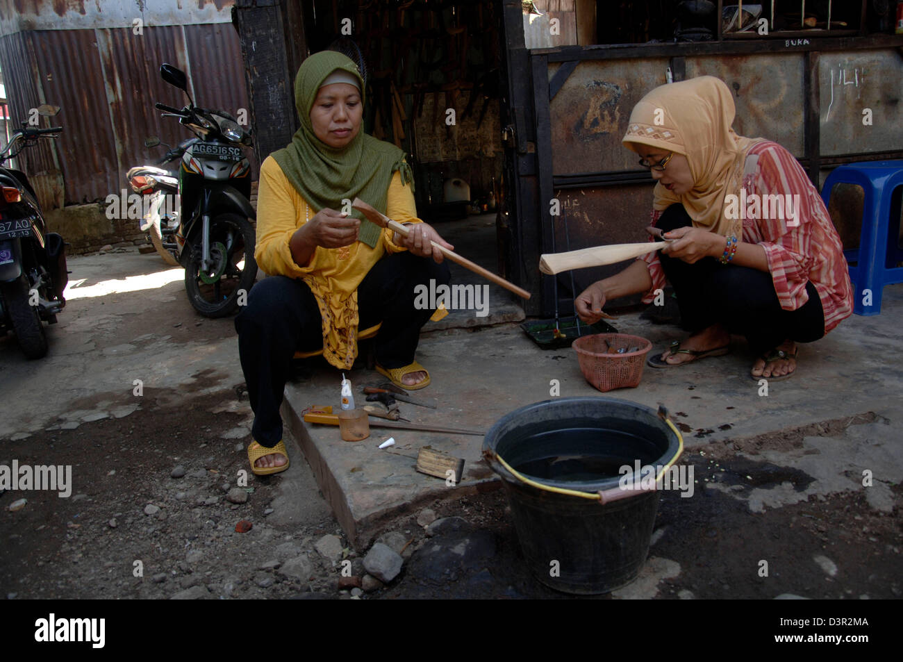 Female kris maker, Hj Mariana (left) and Amah (right) making kris ...