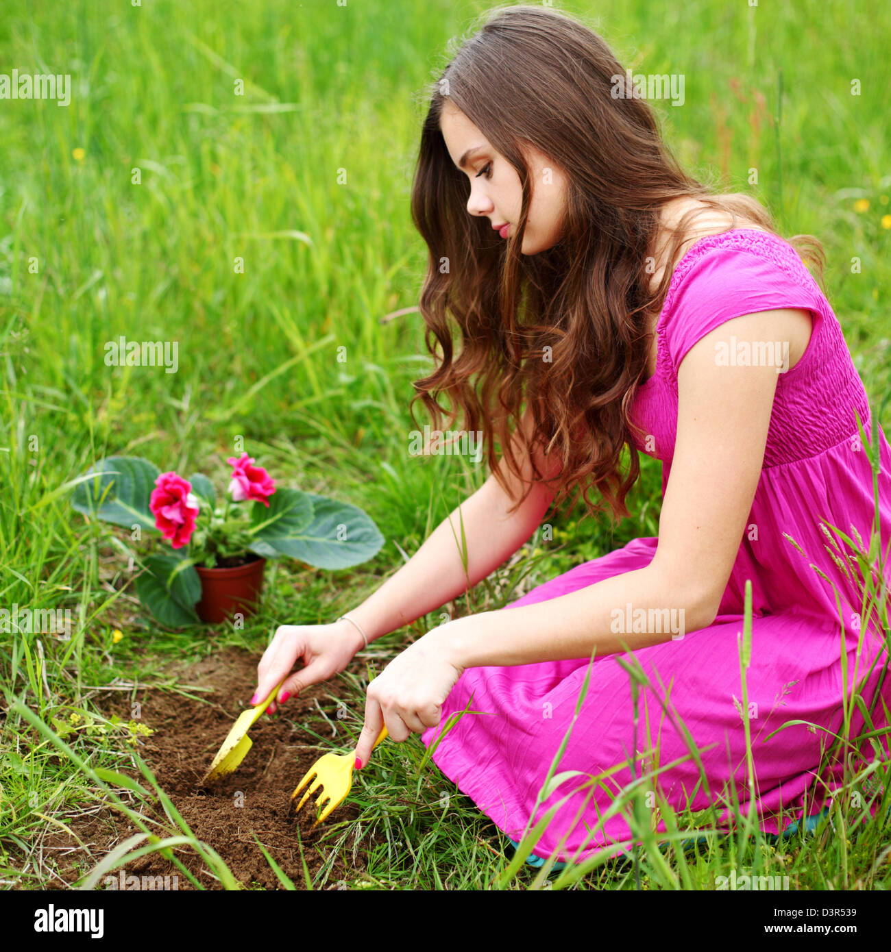 girl grow flower on green field Stock Photo - Alamy