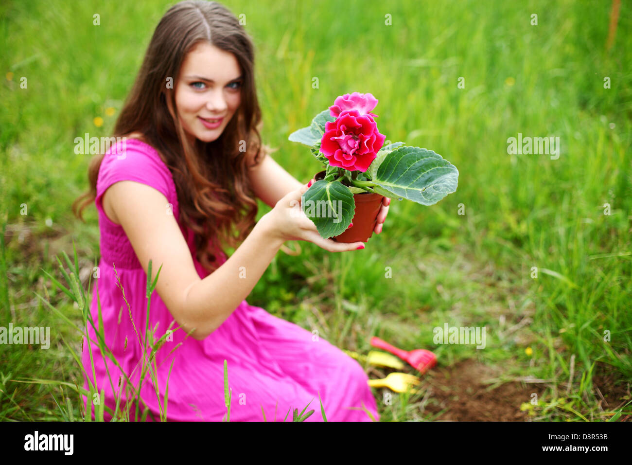 girl grow flower on green field Stock Photo - Alamy