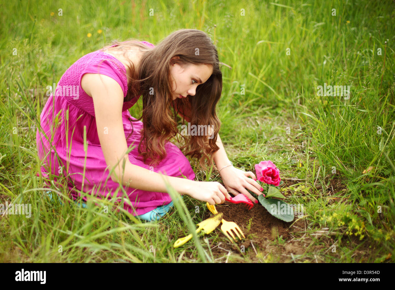 girl grow flower on green field Stock Photo - Alamy