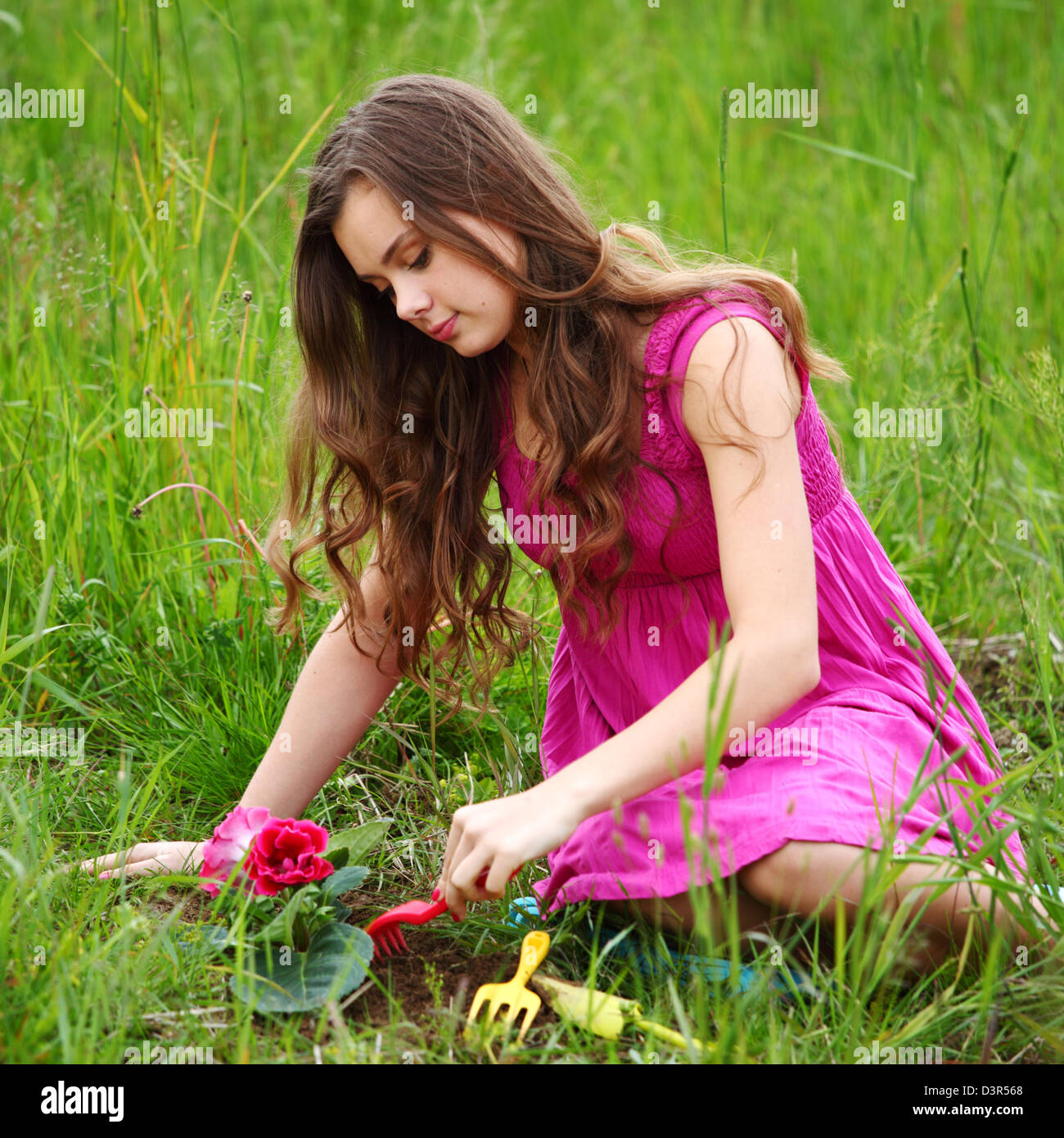 girl grow flower on green field Stock Photo - Alamy