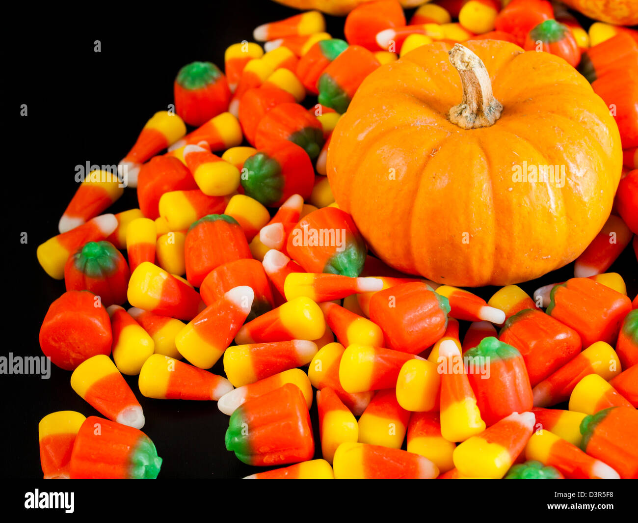Halloween candy corn and pumpkin candies on black background Stock ...