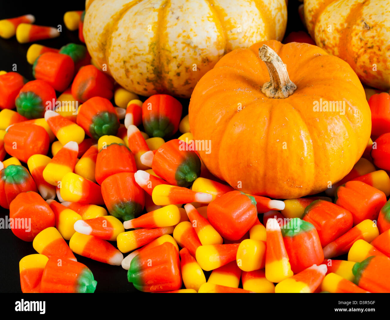 Halloween candy corn and pumpkin candies on black background Stock ...