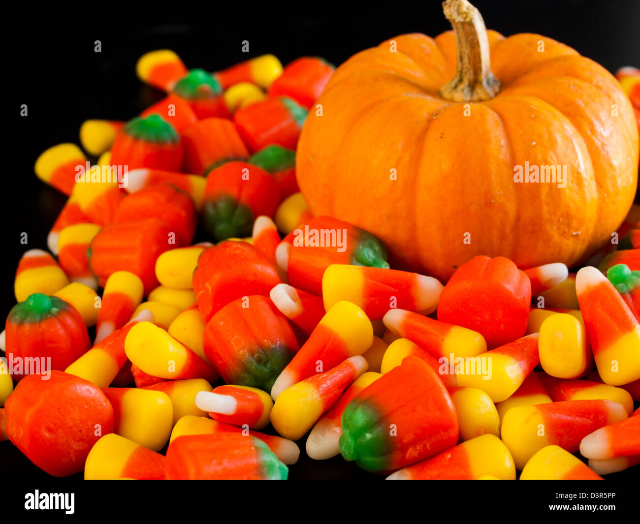 Halloween candy corn and pumpkin candies on black background Stock ...