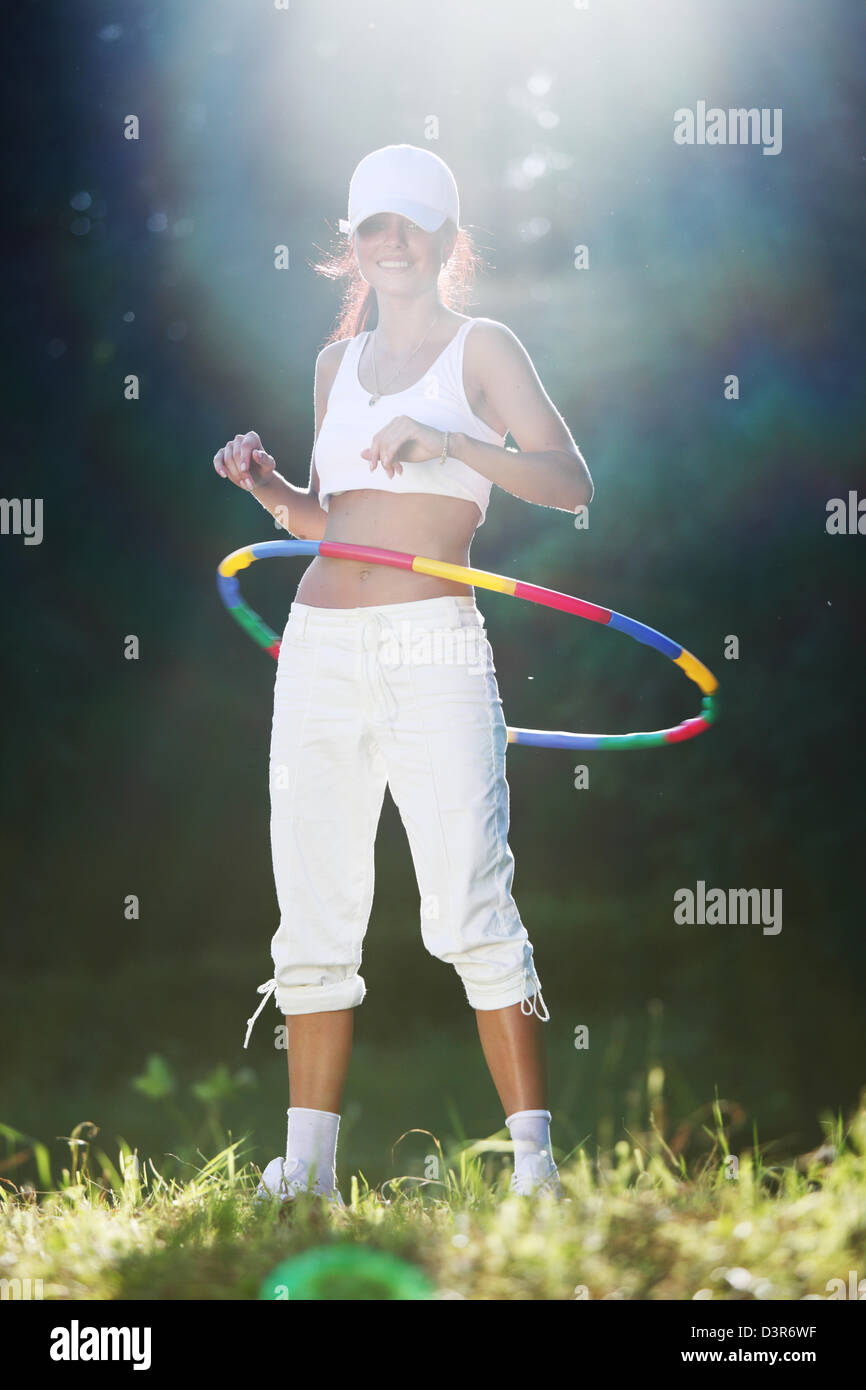 woman rotates hula hoop on nature background Stock Photo - Alamy