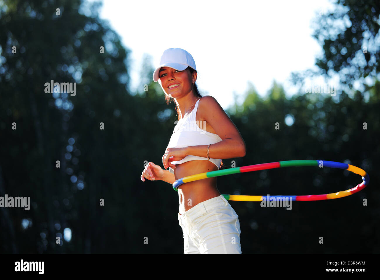 woman rotates hula hoop on nature background Stock Photo - Alamy