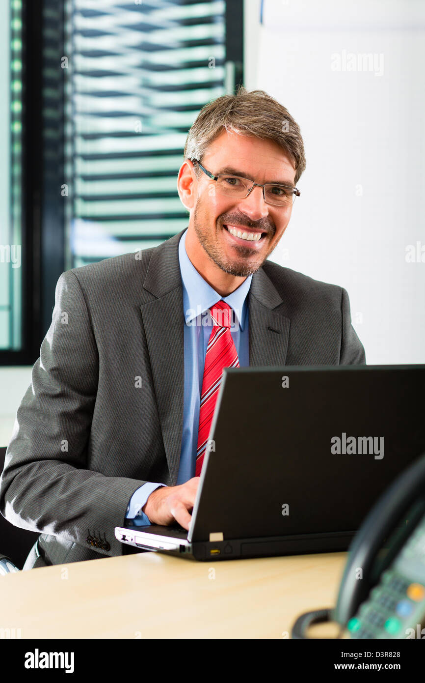 Business - Boss in his office checking mails on laptop computer Stock ...