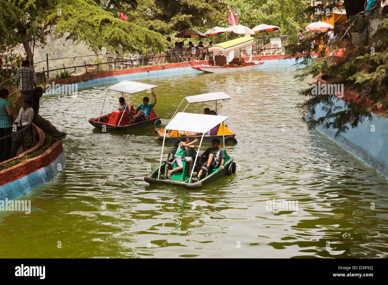 Tourists boating in an artificial canal at Company Bagh, Mussoorie ...