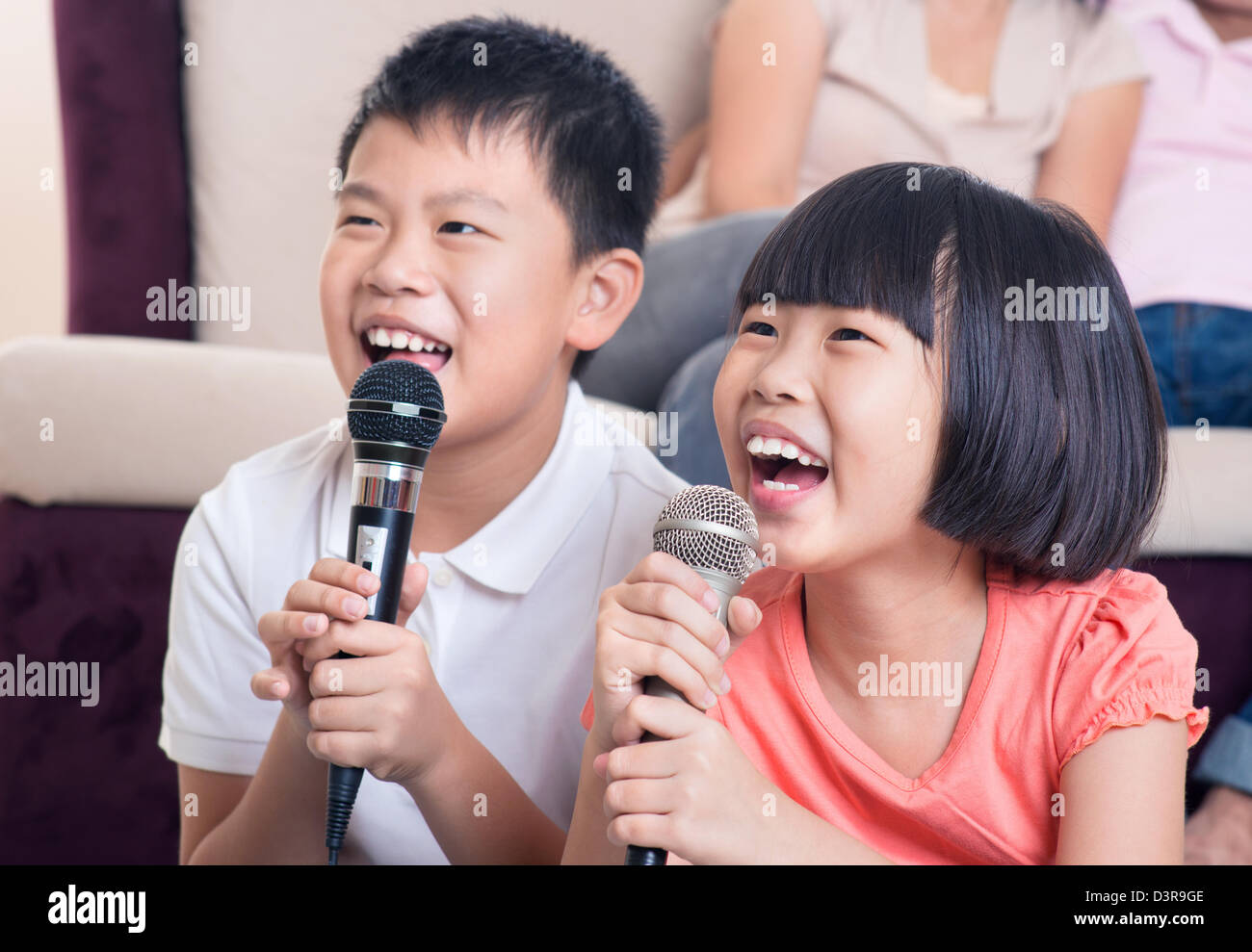 Family at home. Portrait of a happy Asian children singing karaoke ...
