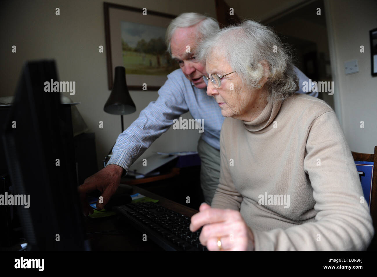 Husband helping wife with a computer at home in his office Stock Photo ...