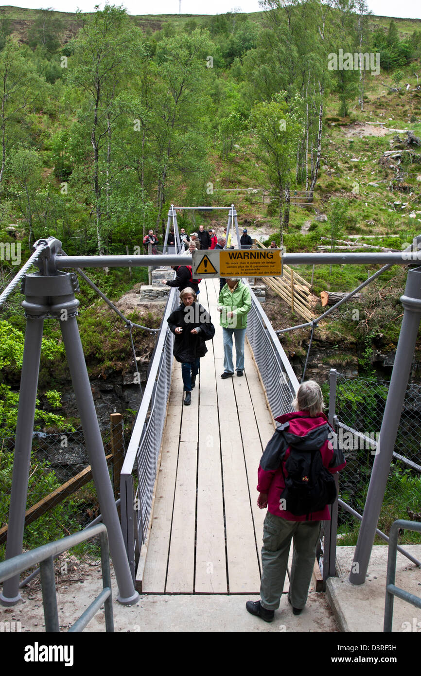 Visitors cross a narrow footbridge at the natural wonder of ...