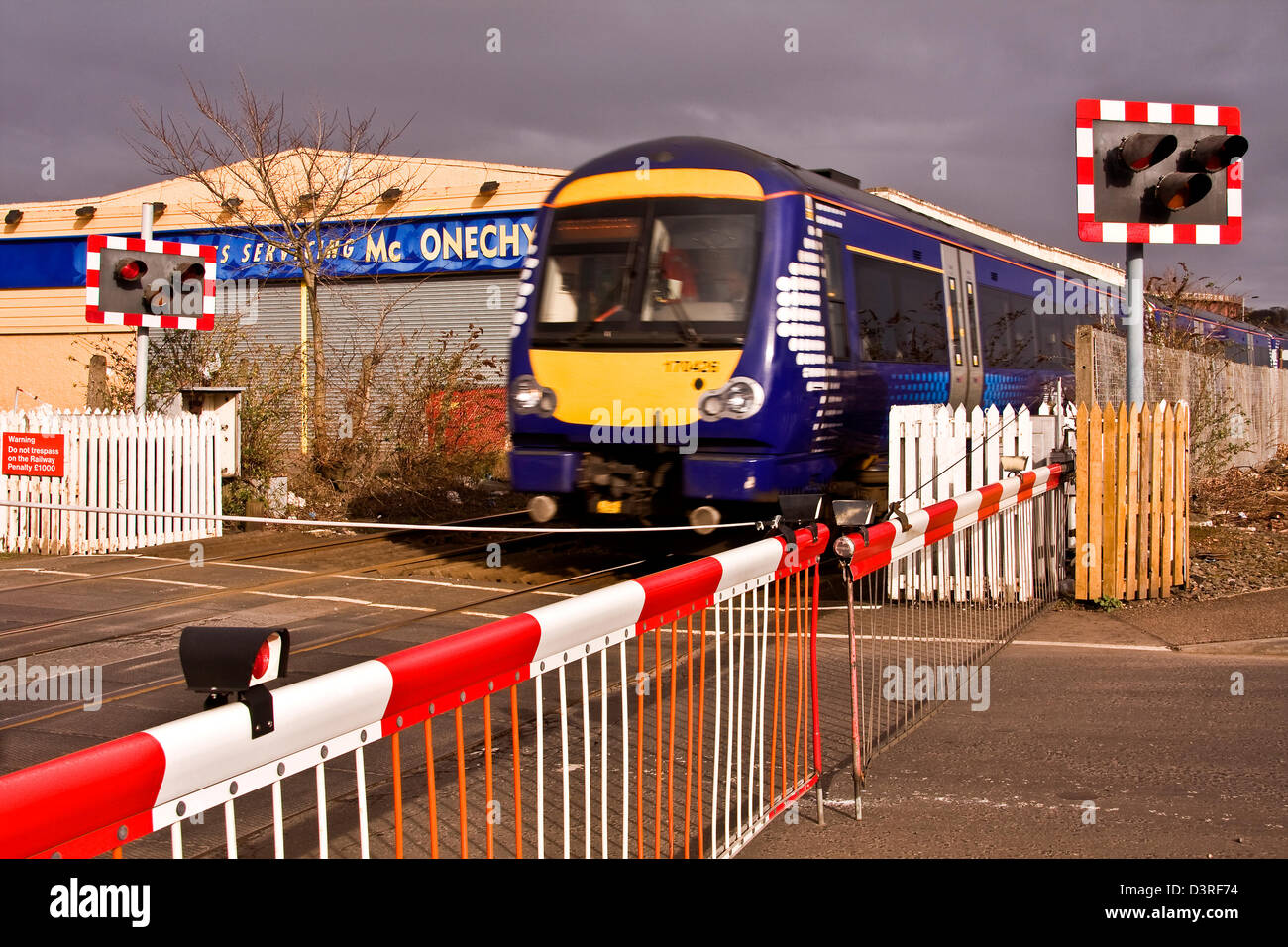 Scotrail commuter train approaching a level crossing travelling towards ...