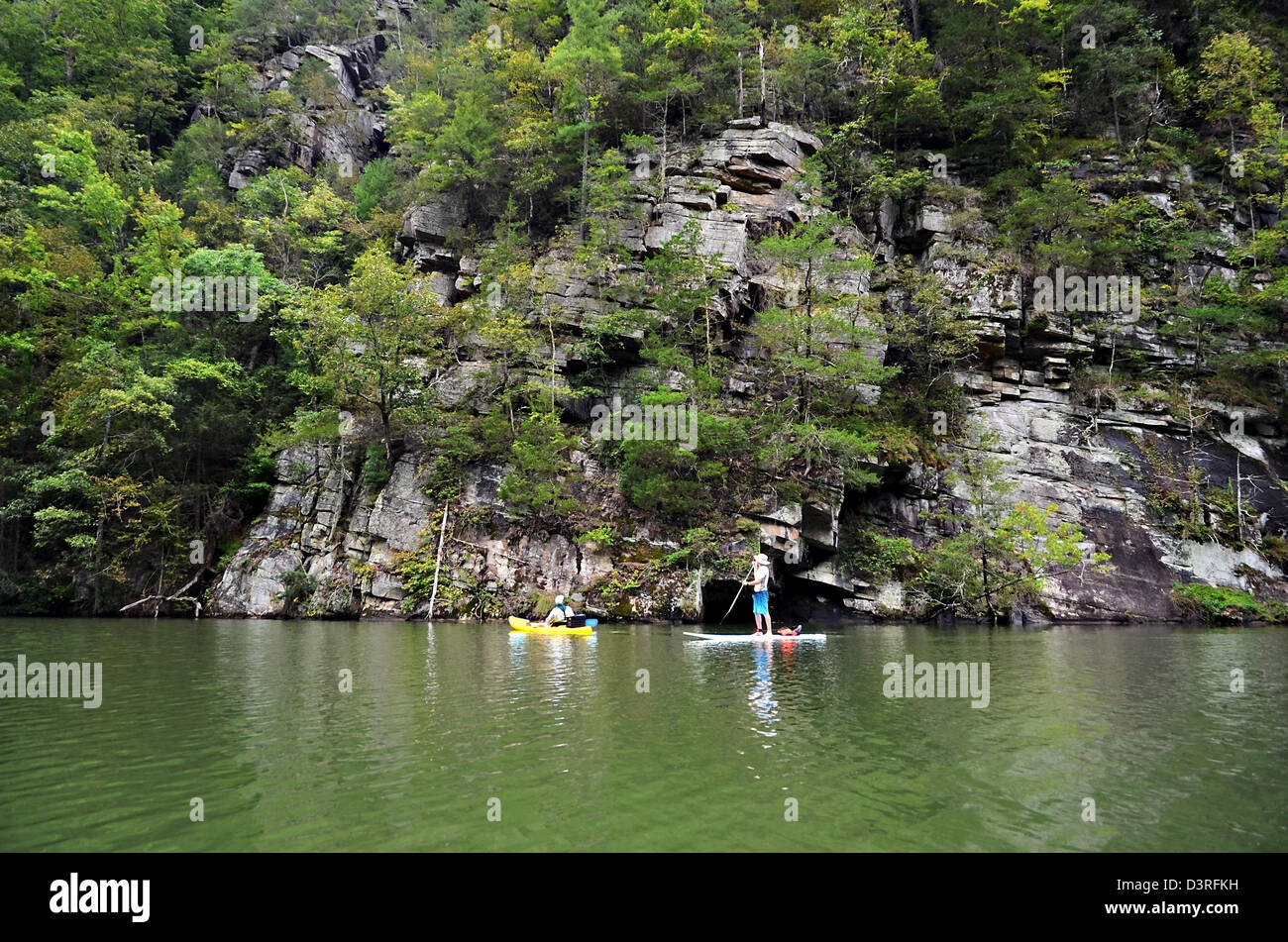 Men in kayak and canoe below a large rock wall on a lake Stock Photo ...