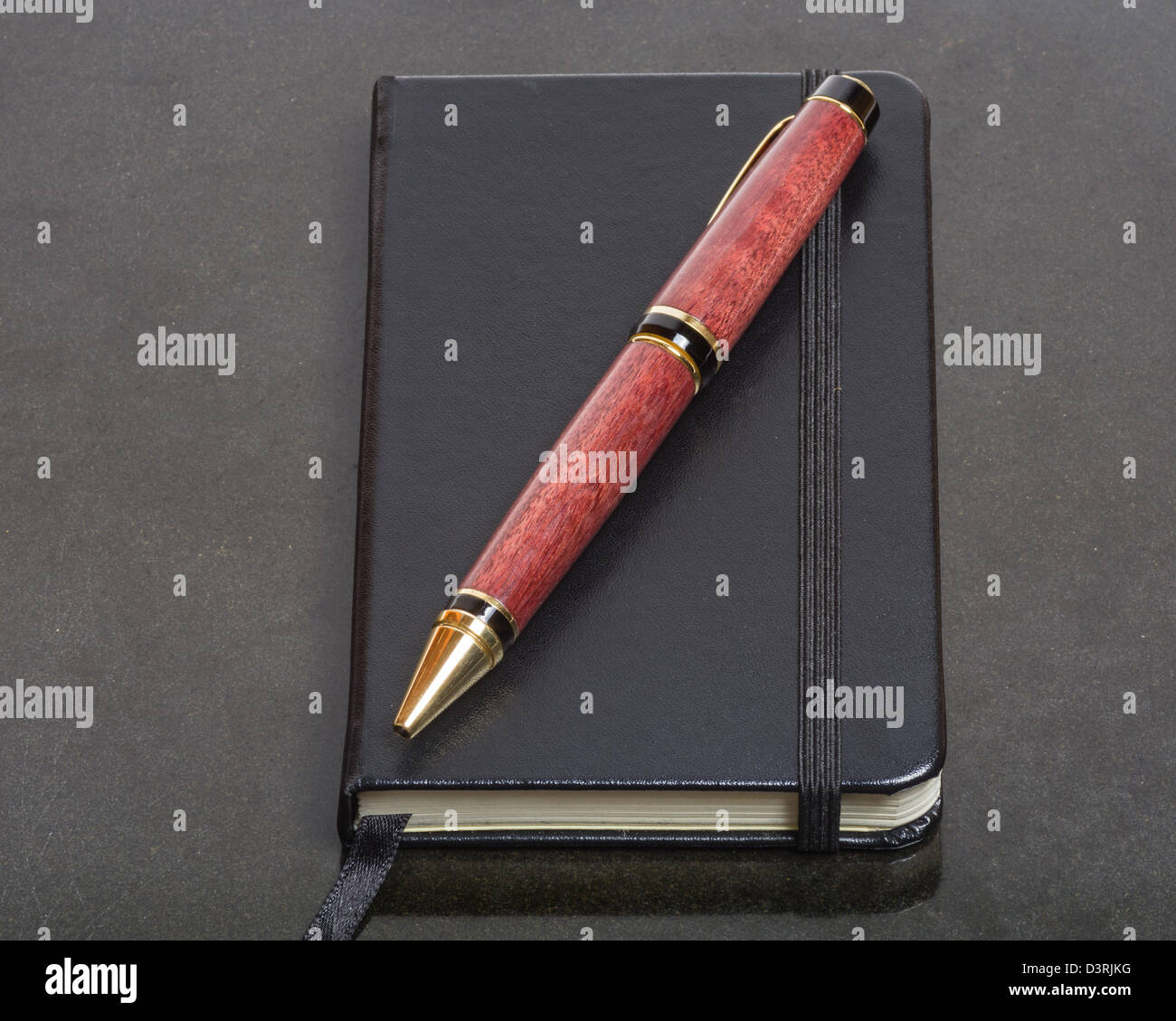 Black notebook and pen on a desk Stock Photo - Alamy