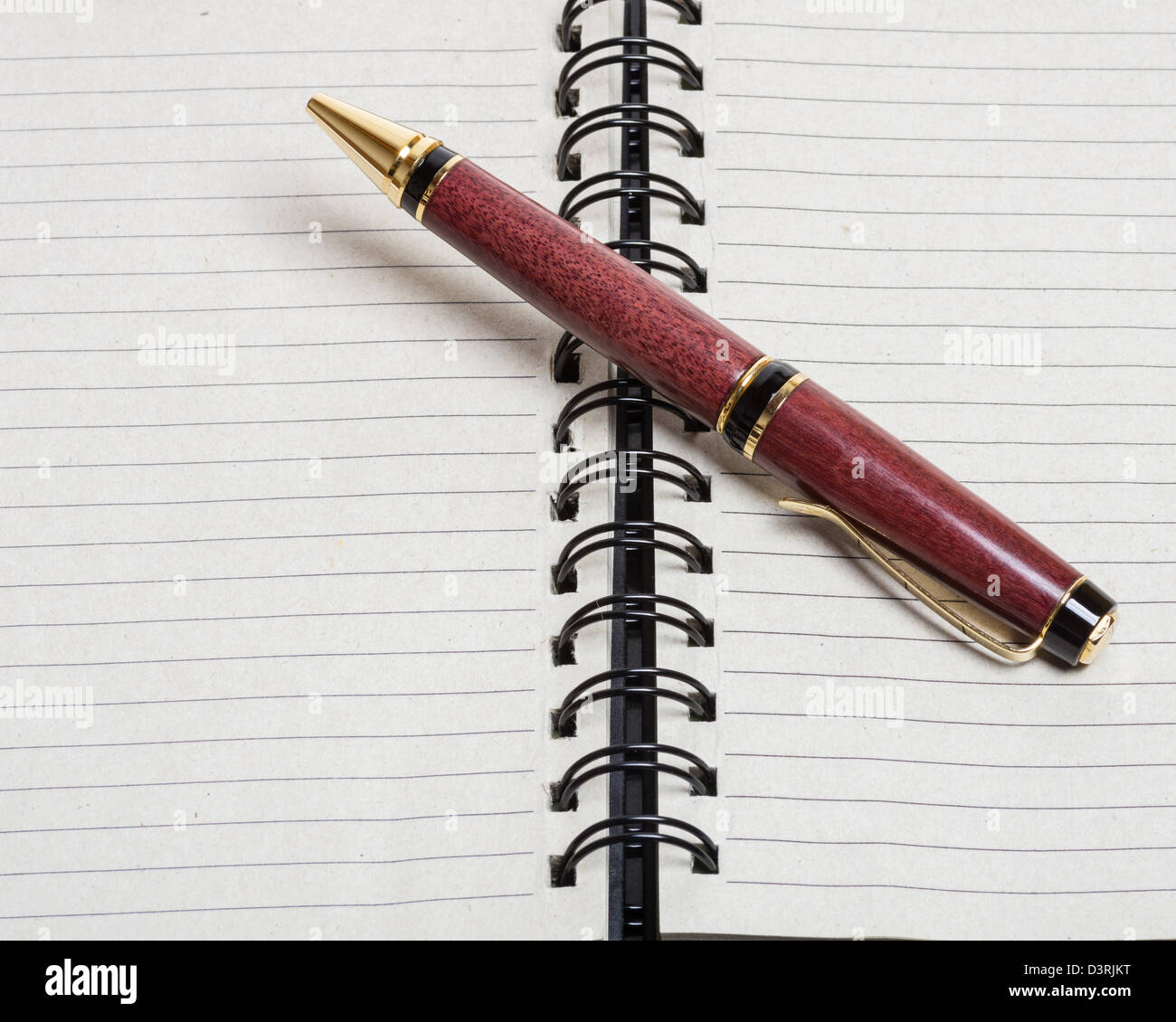 A spiral notebook on a desk with expensive pen Stock Photo - Alamy