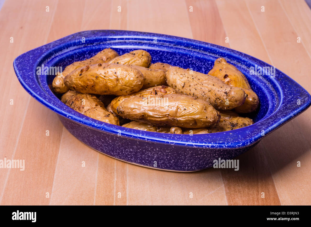 A blue dish with baked fingerling potatoes Stock Photo - Alamy