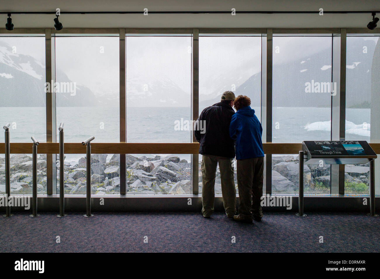 Tourist looks out large windows, Boggs Visitor Center, Portage Lake ...