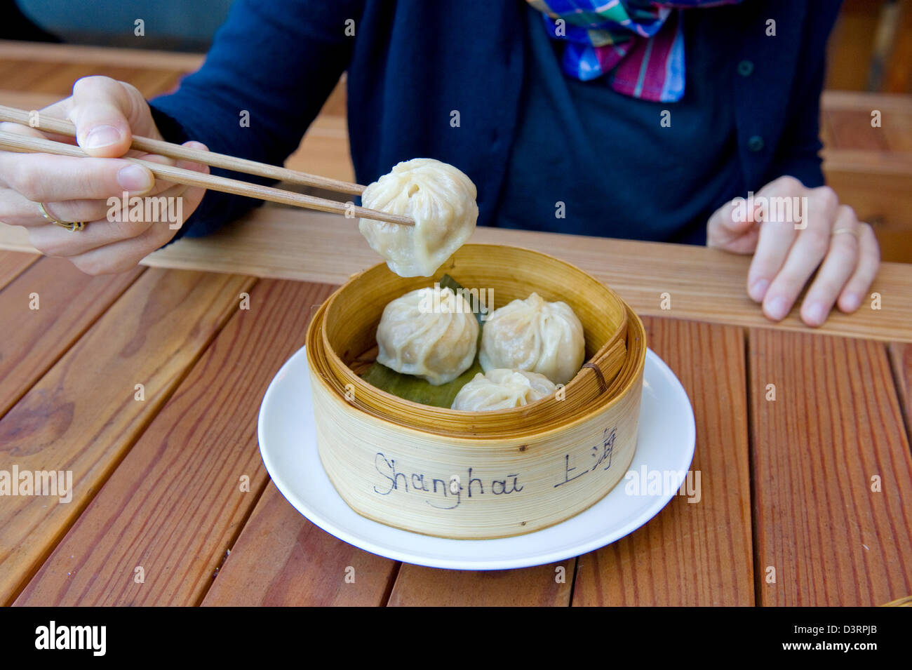 Berlin, Germany, a woman eating dim sum with chopsticks Stock Photo - Alamy