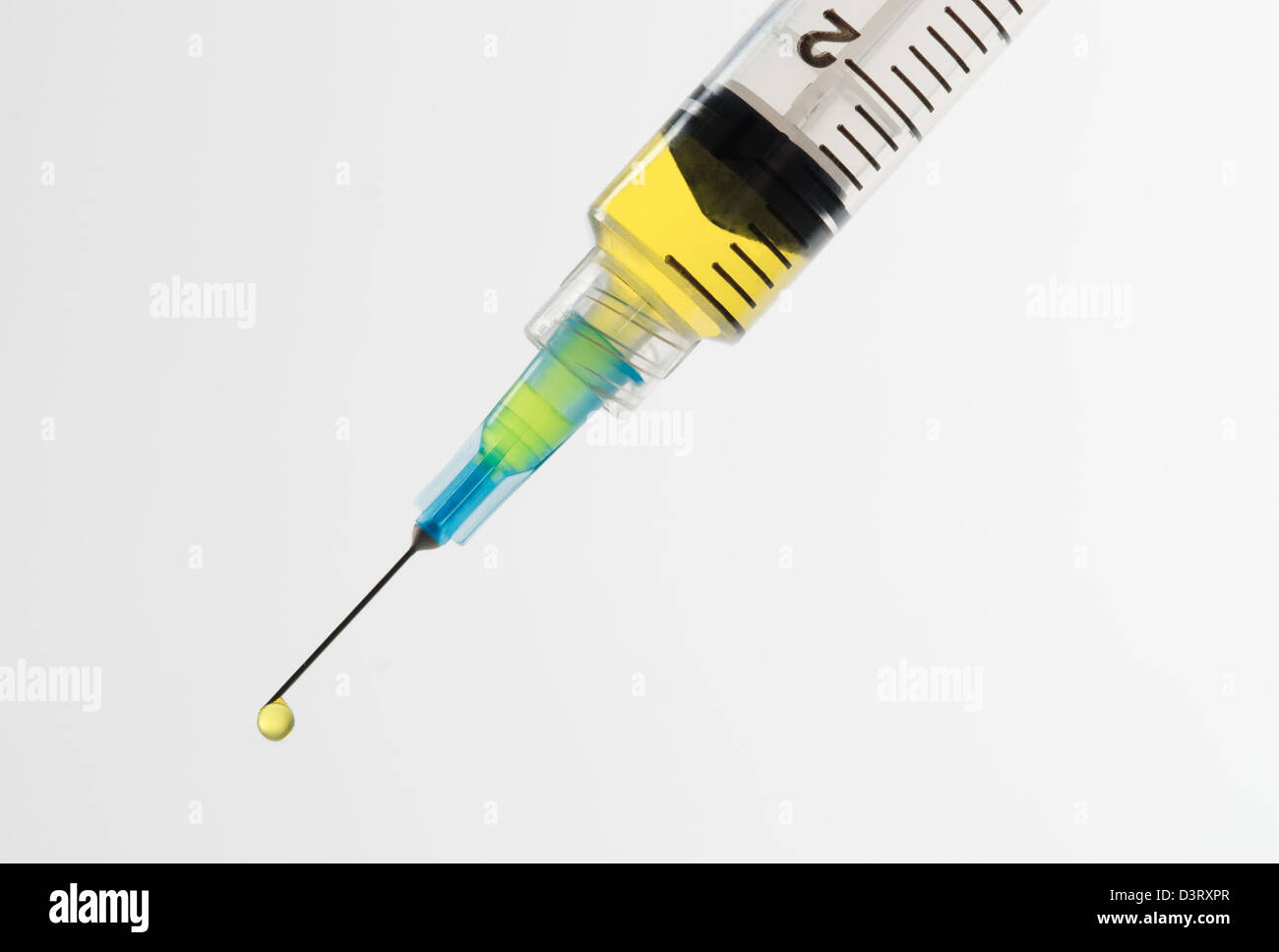 Hypodermic syringe and needle with drop of yellow medicine isolated on ...