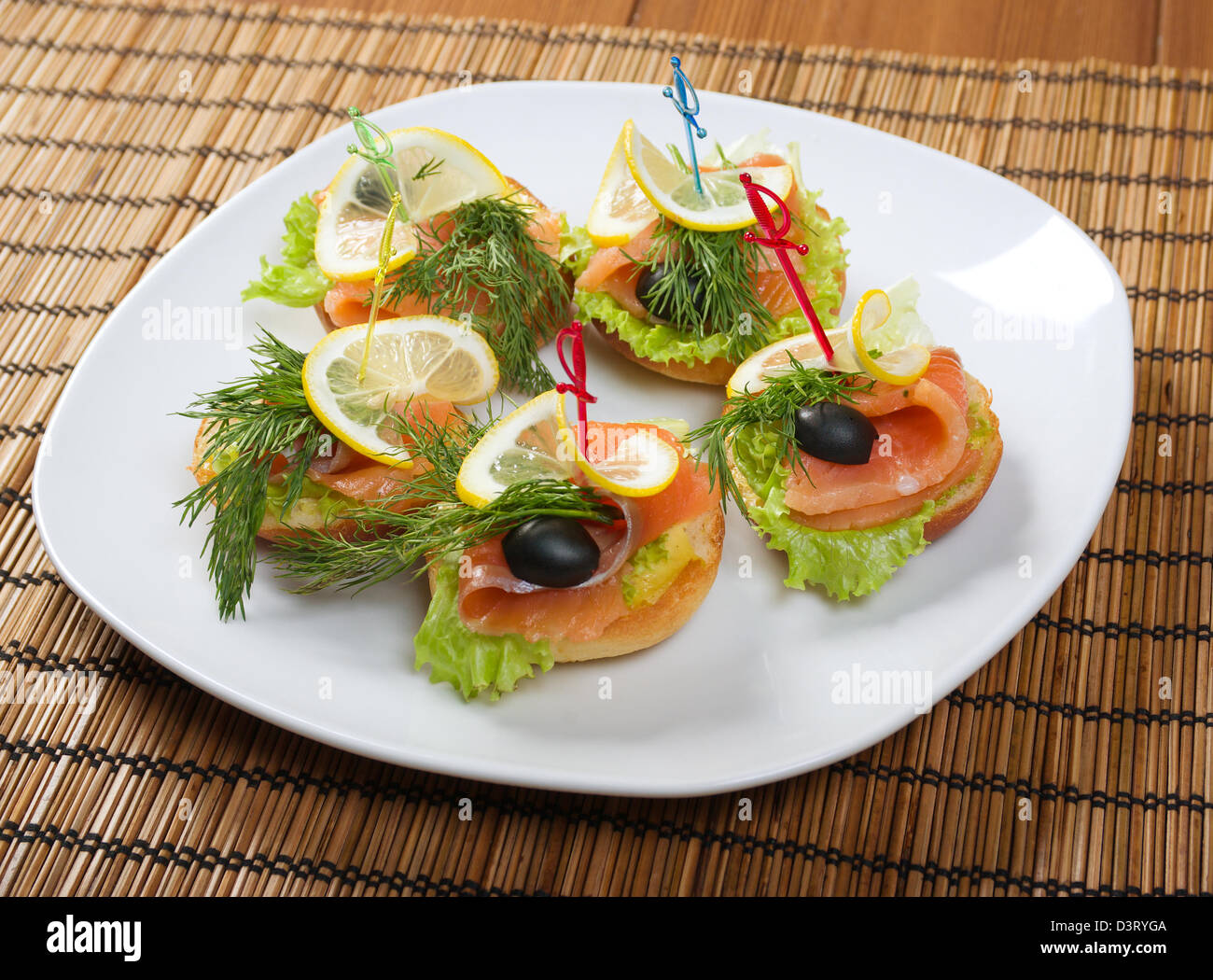 Canapes with Smoked Salmon and lemon on plate Stock Photo - Alamy
