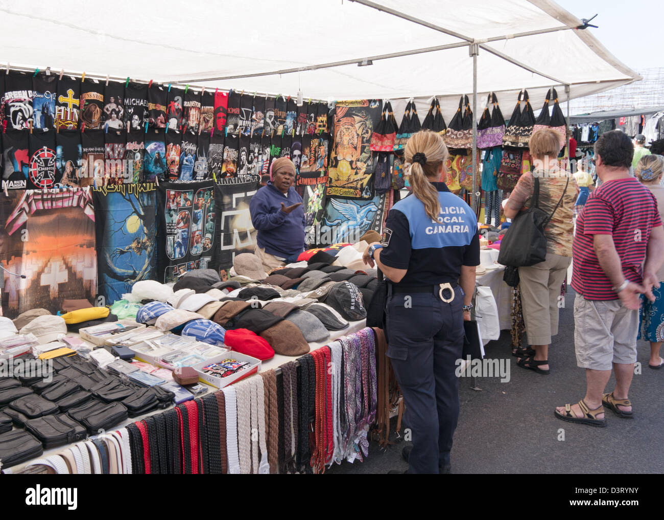 A black stall holder talks to a police woman Puerto de Mogan open air ...