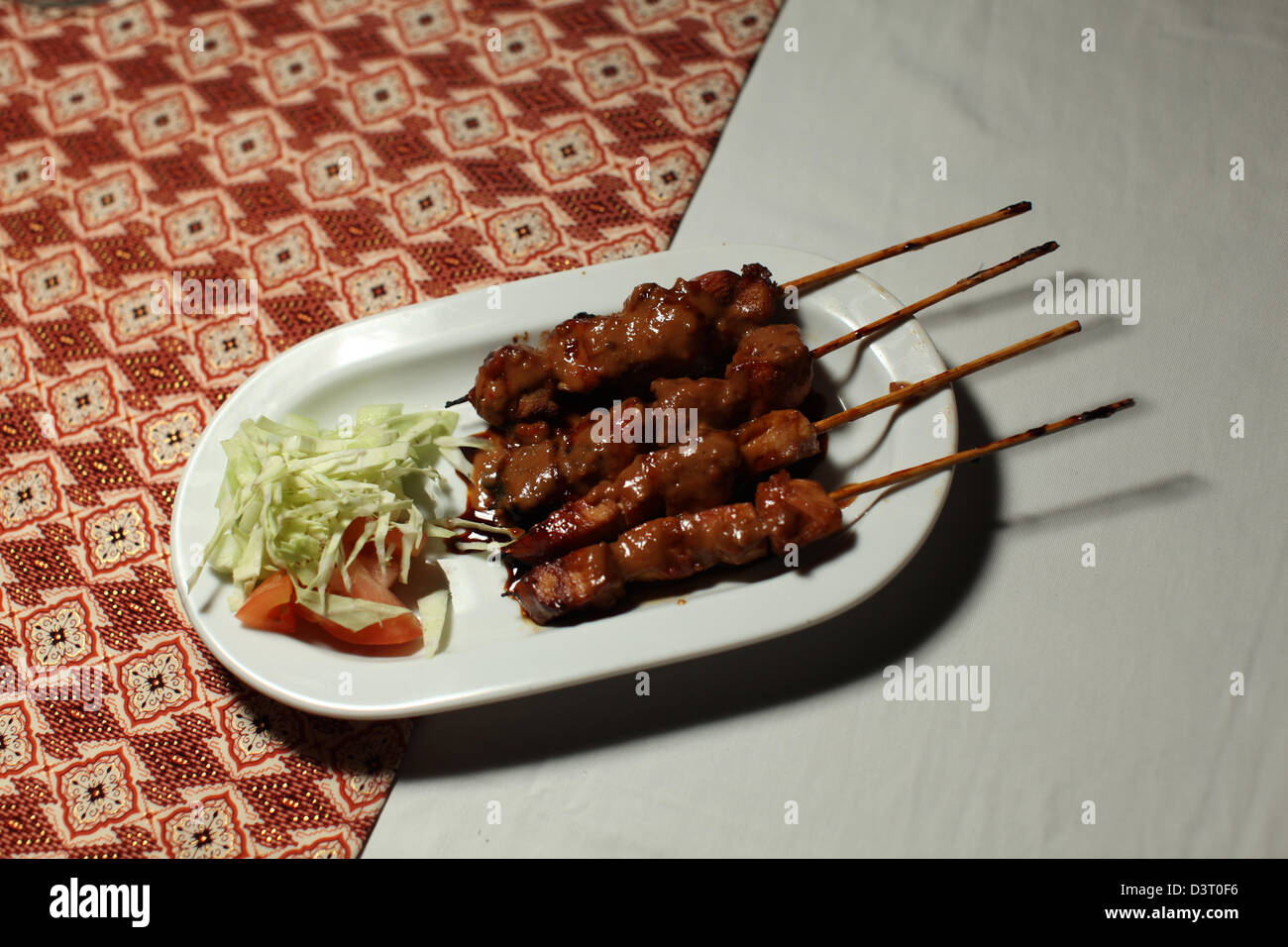 A plate of chicken satay, which is an Indonesian food. The chicken is ...
