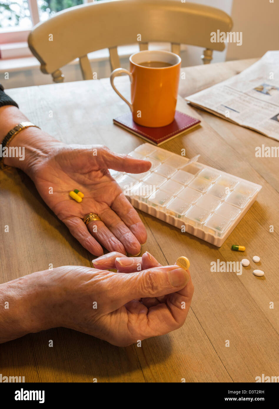 WOMAN AT TABLE WITH PILLBOX TAKING MEDICINE SORTING PILLS UK Stock ...
