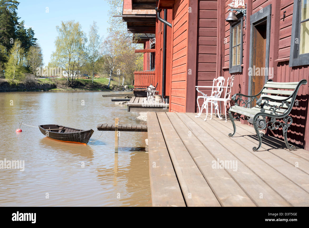 Small rowing boat tied up to a short pier outside one of the ...