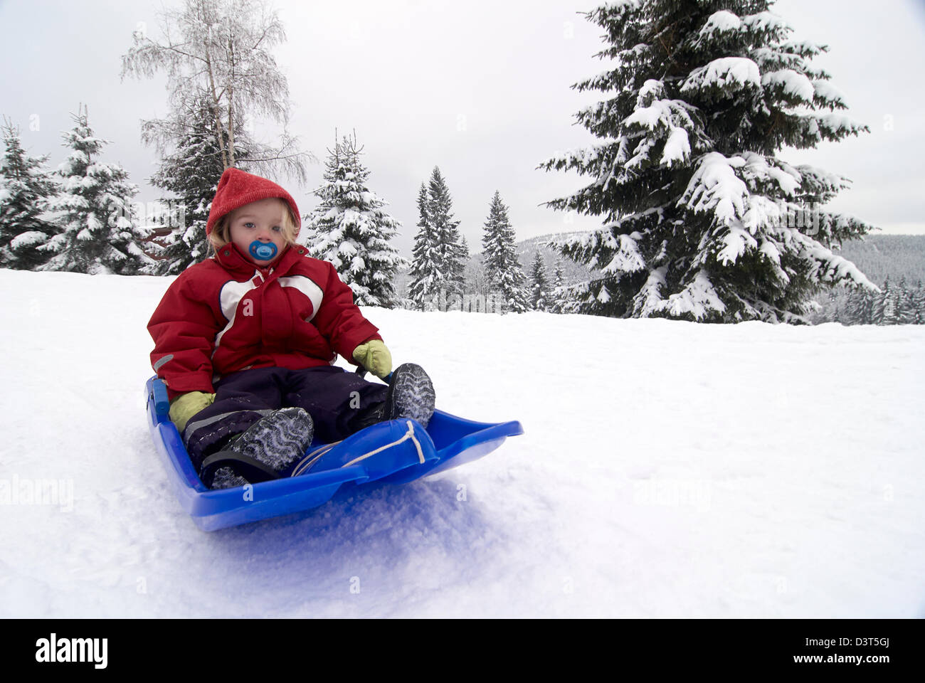 Sledding 2 year old girl on mountain, winter season, snow Stock Photo ...