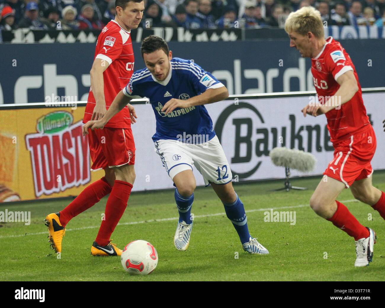Gelsenkirchen, Germany, 23rd Feb, 2013. Schalke's Marco Hoeger (M) vies ...