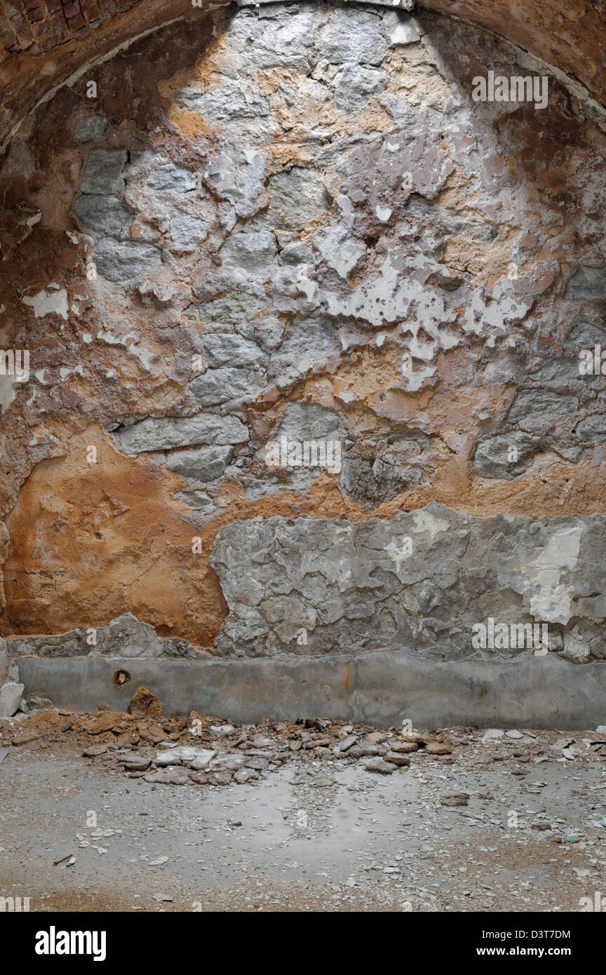 Rough rock wall background of decaying masonry with overhead skylight ...