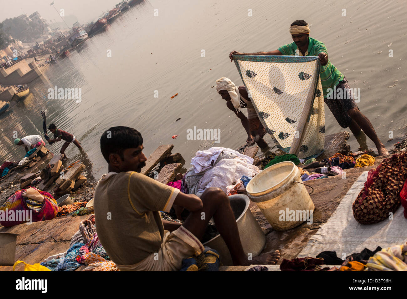 Indian men hand washing clothes in the Ganges river, Varanasi, India ...