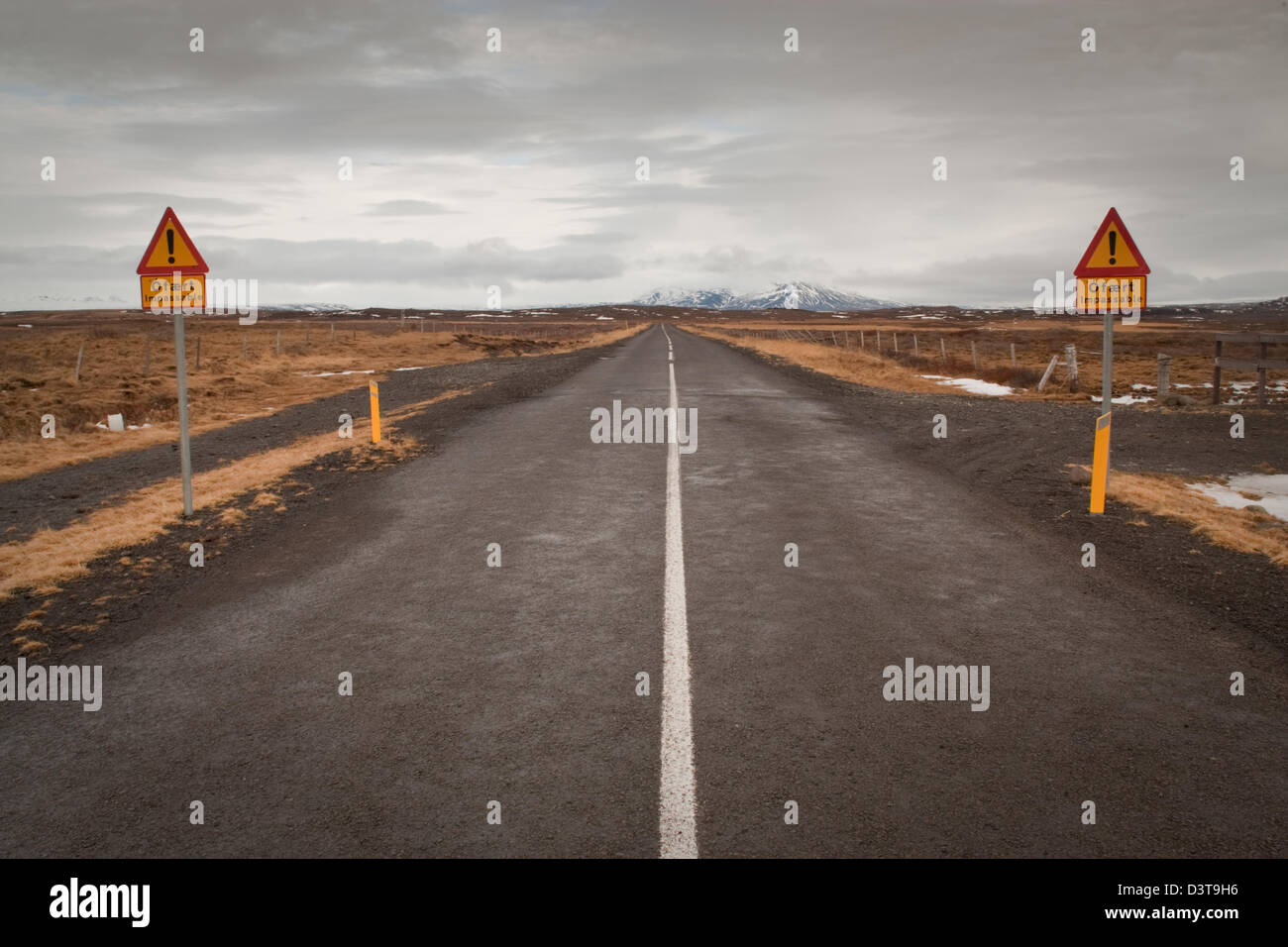 Empty road in rural Iceland with two road signs saying road impassable ...
