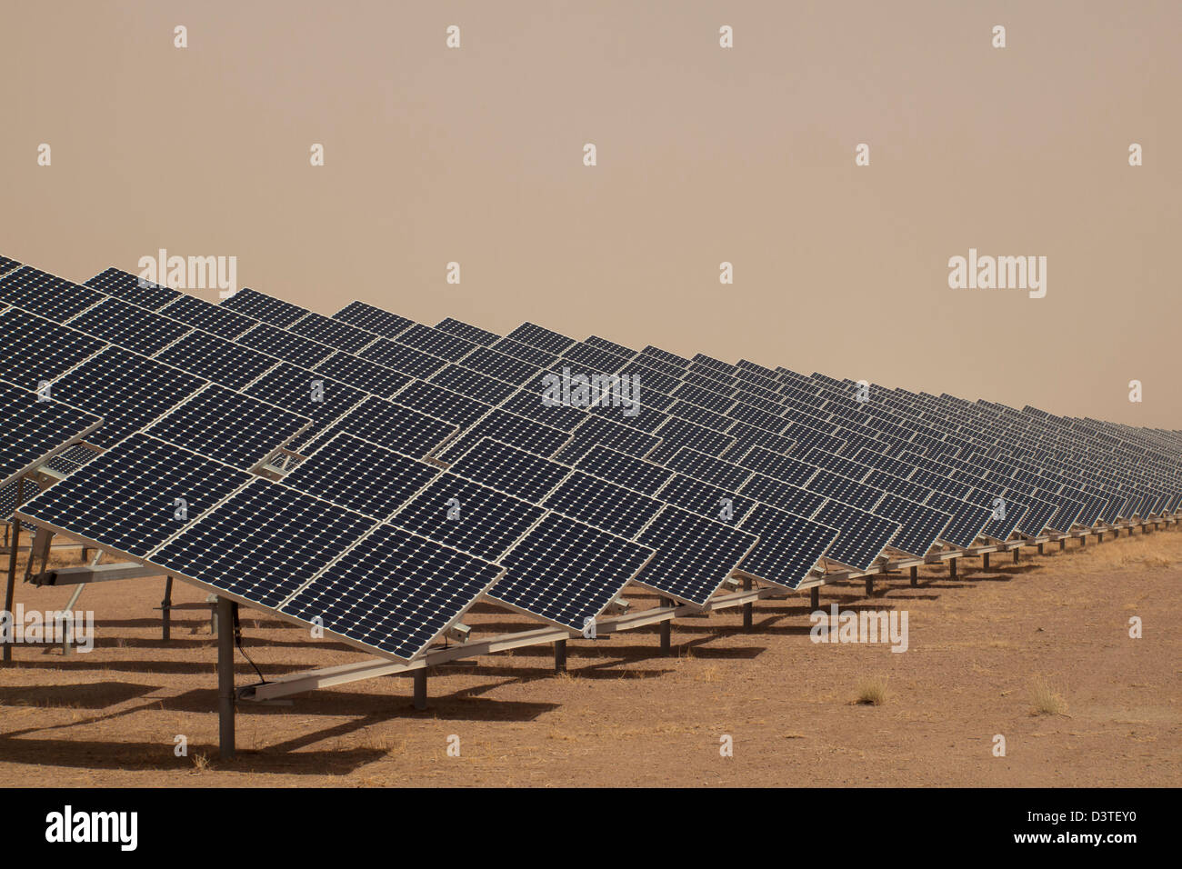 A series of large solar panels forms a symmetrical line at a power ...