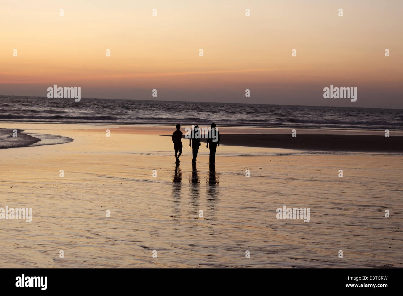 Three Men Beach At Sunset Stock Photo - Alamy