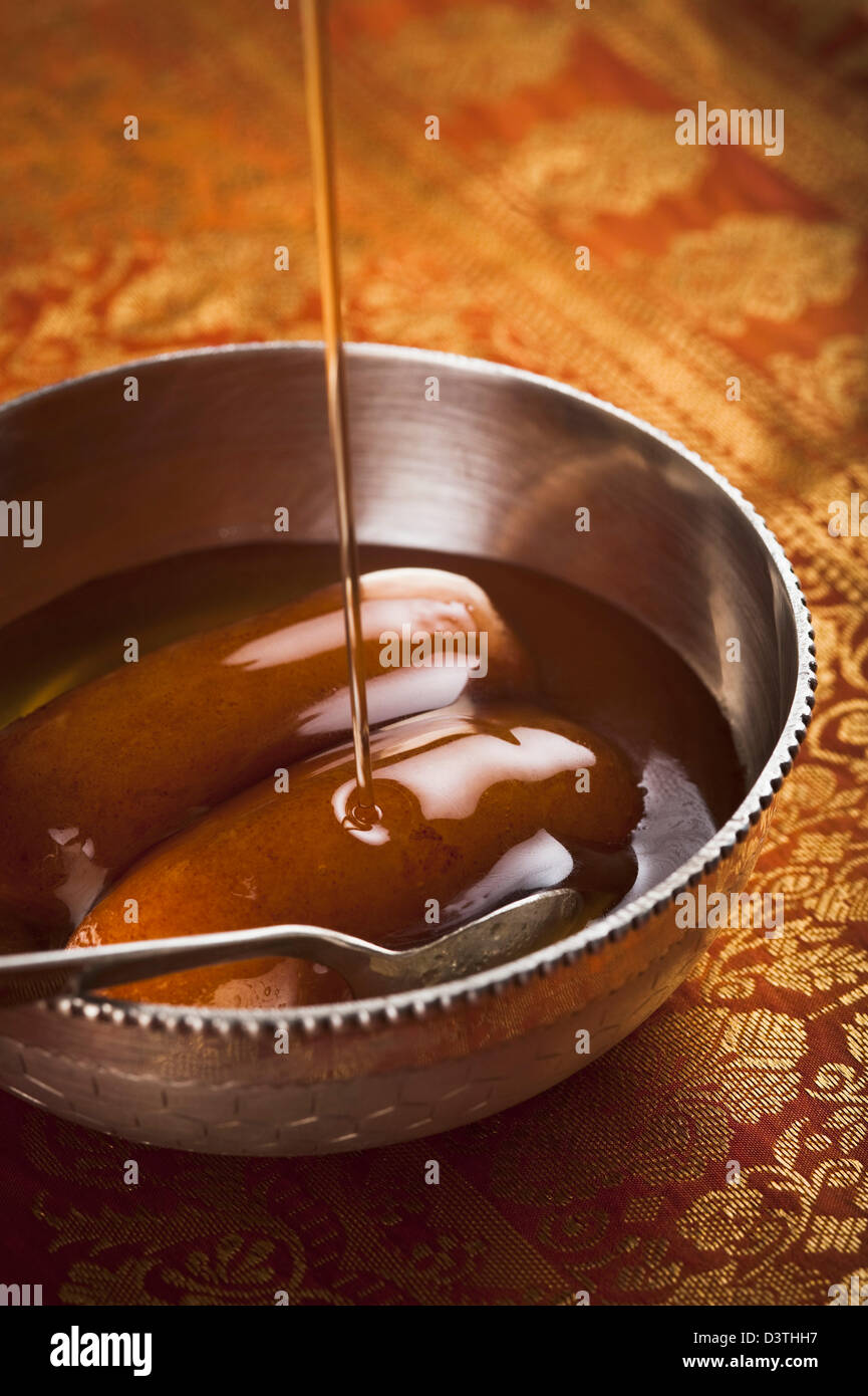Sugar syrup being poured on gulab jamuns Stock Photo - Alamy