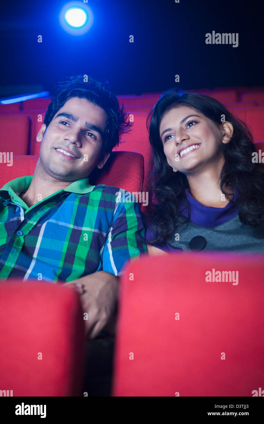 Couple enjoying movie in a cinema hall Stock Photo - Alamy