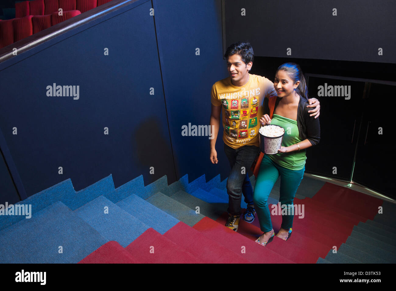 Couple moving up on steps in a cinema hall Stock Photo - Alamy