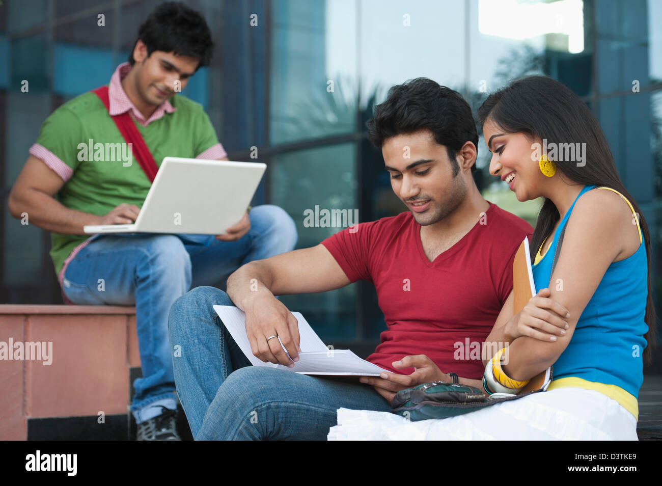 University students discussing on notes in university campus Stock ...
