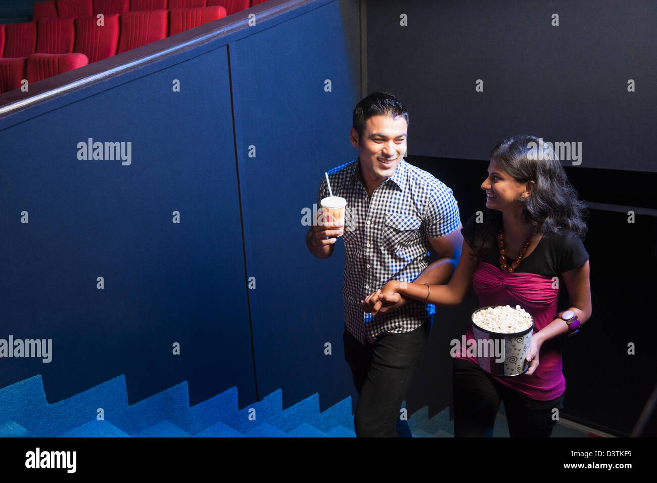 Couple moving up on steps in a cinema hall Stock Photo - Alamy