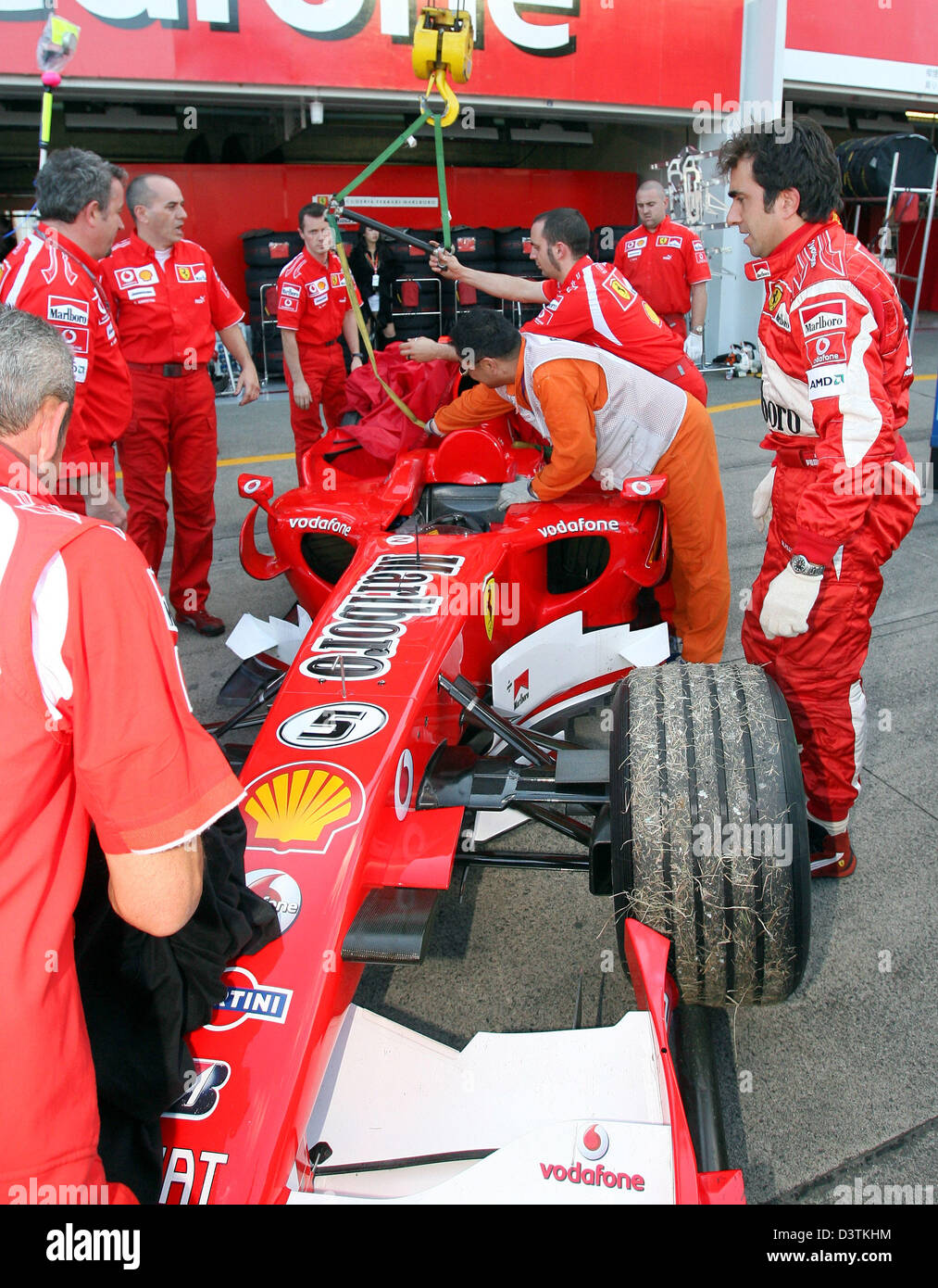 Mechanics unload the damaged car of German Formula One pilot Michael ...