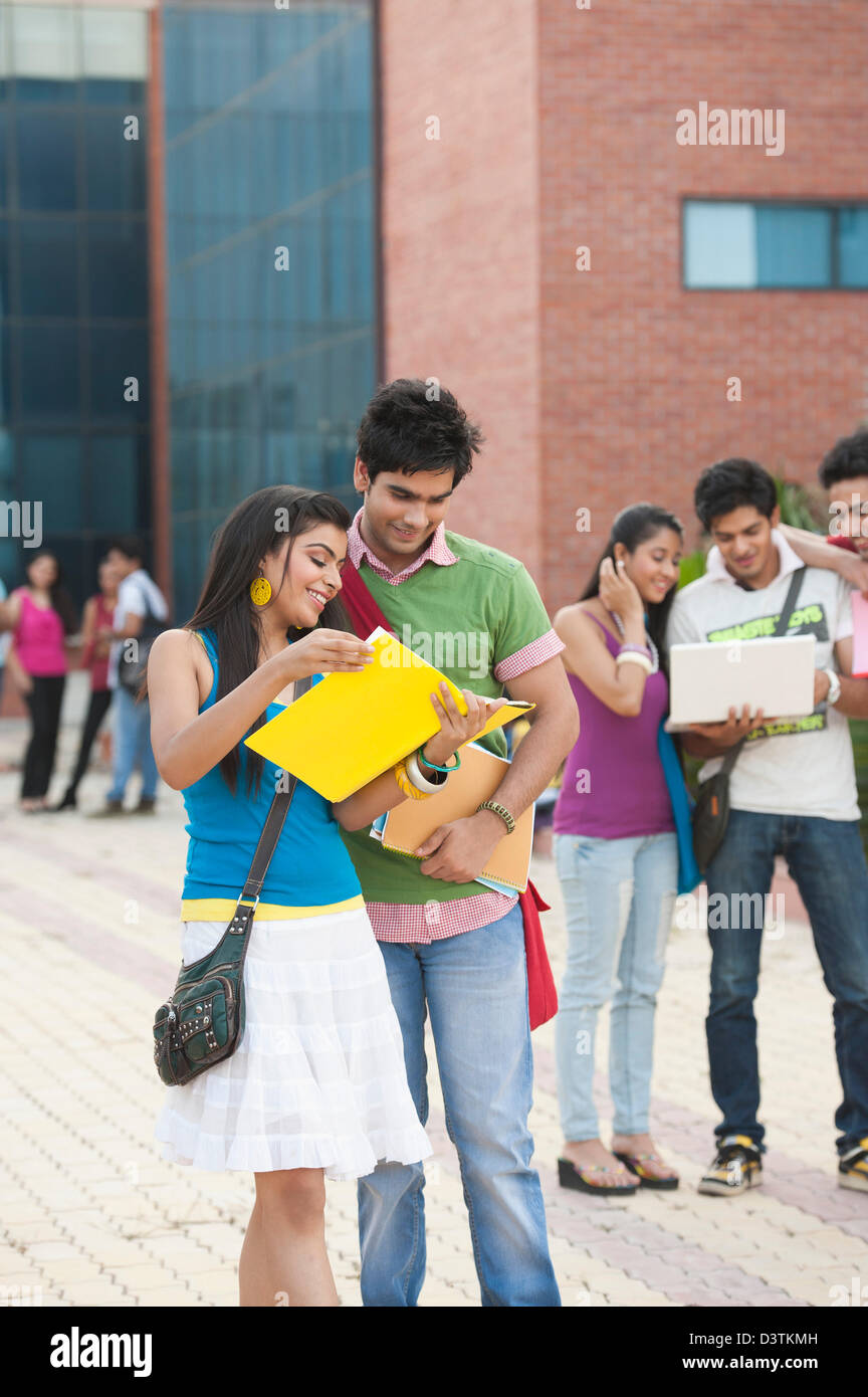 University students reading a book in university campus Stock Photo - Alamy
