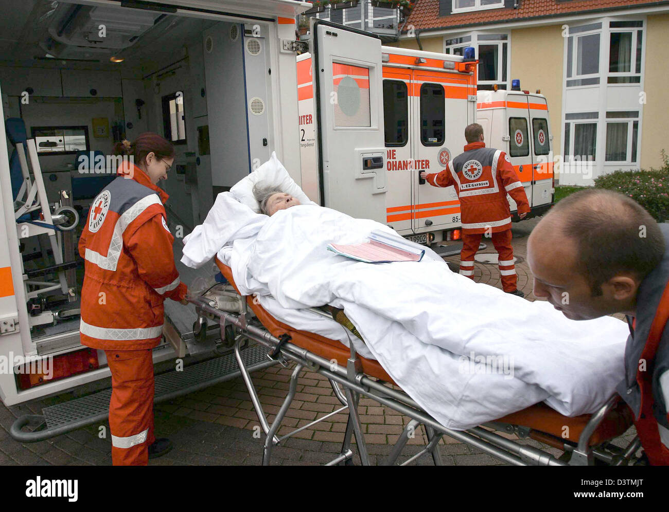 Residents of a home of the elderly are being led away by paramedics ...