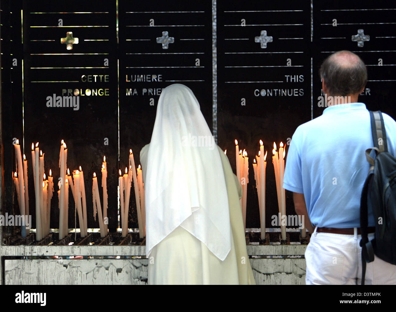 (dpa file) - A nun with a white veil and a pilgrim stand in front of a ...