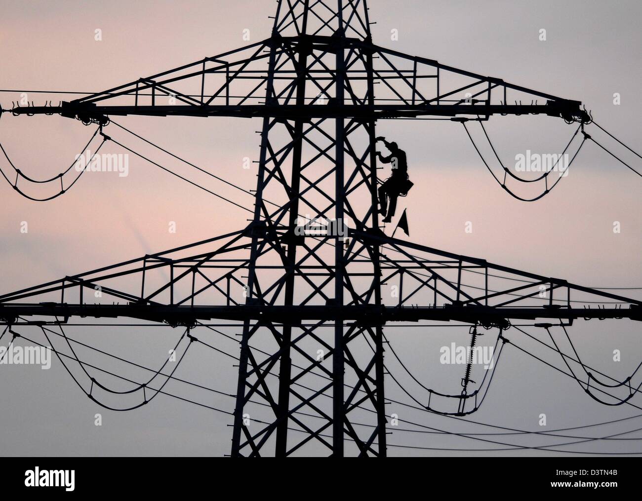 A man climbs up a power pole for maintenance works in Pfatter, Germany ...