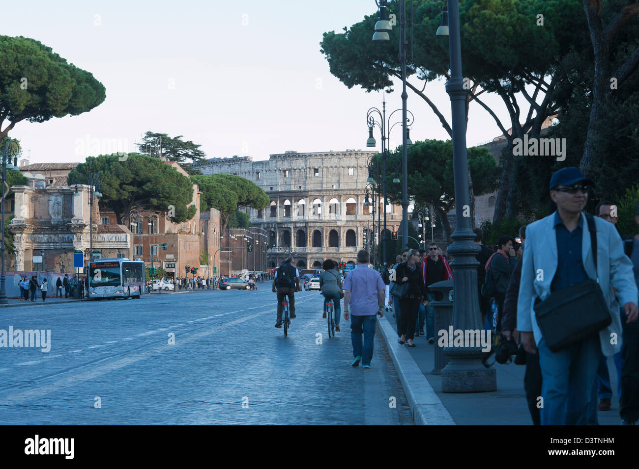 Tourists walking on the street with amphitheatre in the background ...