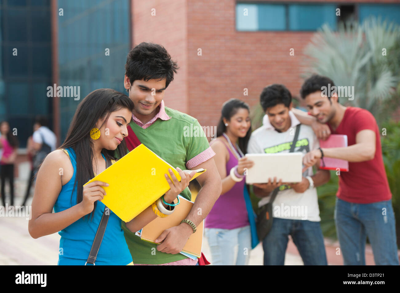 University students reading a book in university campus Stock Photo - Alamy