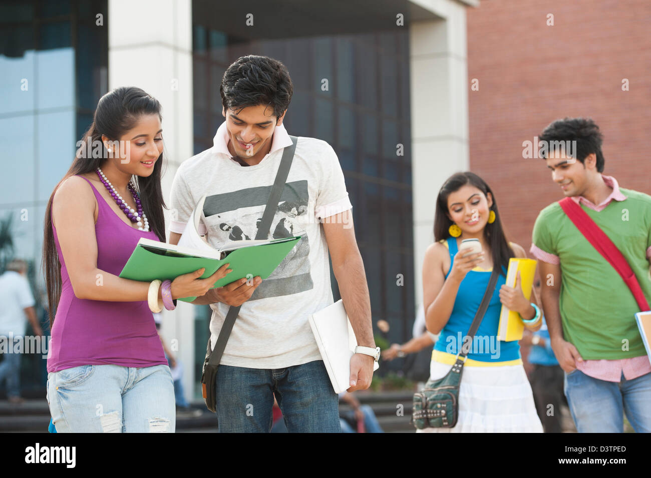 University students reading a book in university campus Stock Photo - Alamy