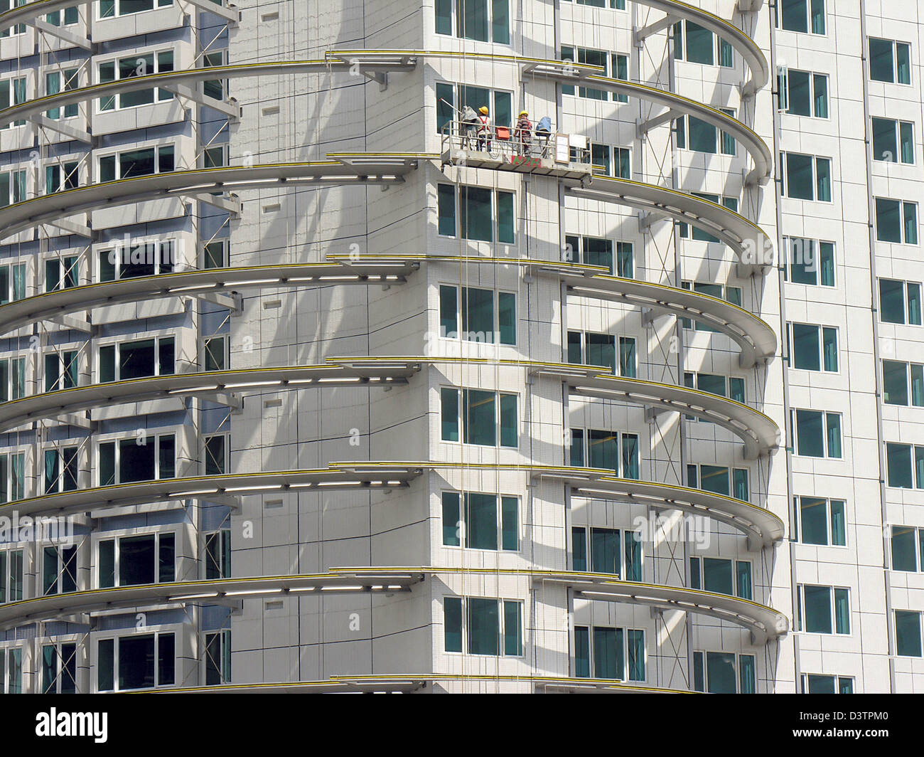 Window cleaners work on the cladding of a tenement block in Hong Kong ...