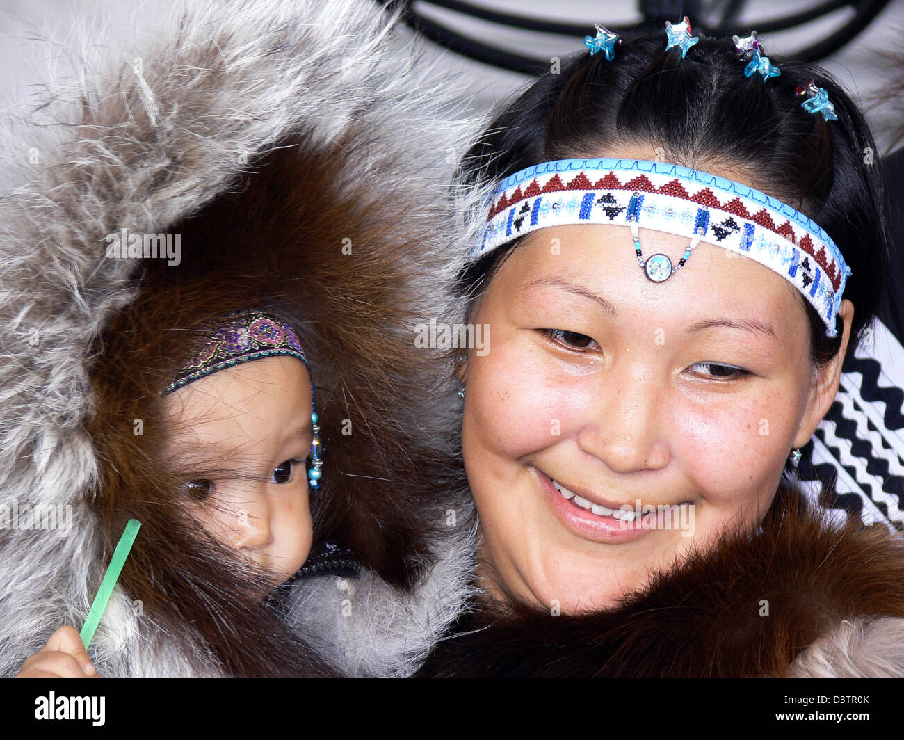 An Inuit woman and her baby dressed in traditional attire decorated ...